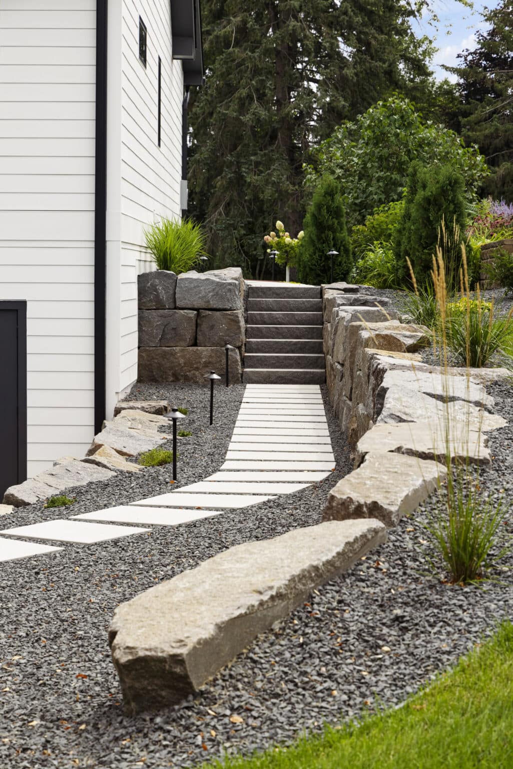 Backyard boulder wall w/ pathway and lighting – Gary Anderson Landscaping